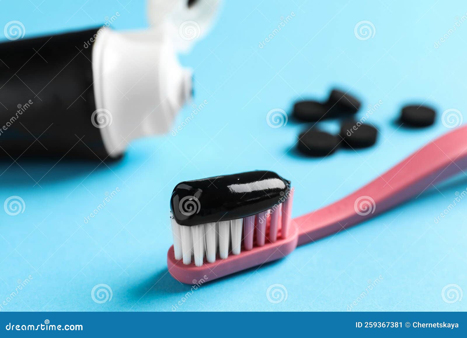 Brush with Charcoal Toothpaste on Light Blue Background, Closeup Stock ...