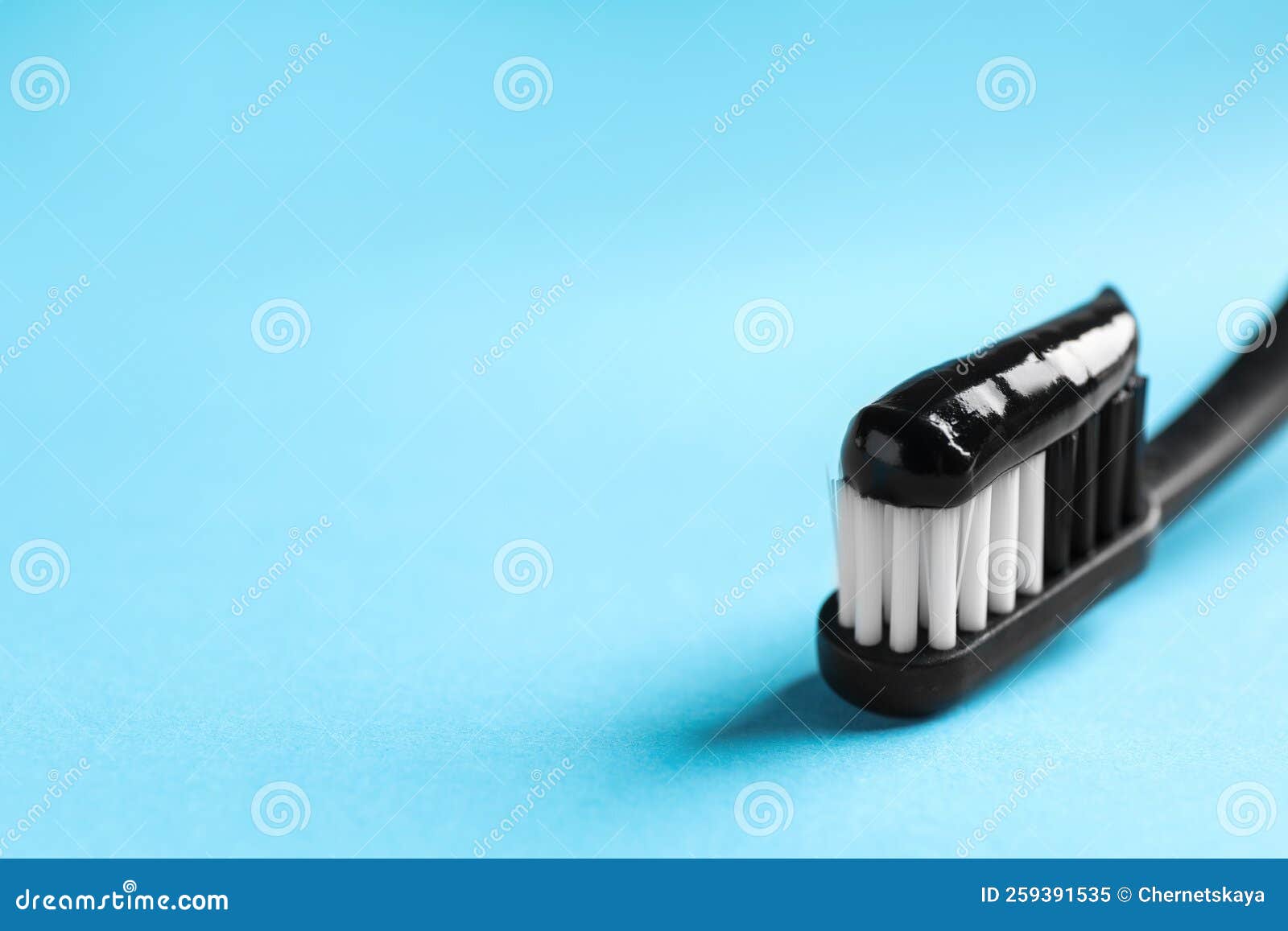 Brush with Charcoal Toothpaste on Light Blue Background, Closeup. Space ...