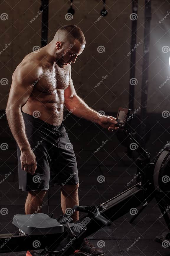 Brutal Bodybuilder Controlling the Speed of Training on the Rowing ...