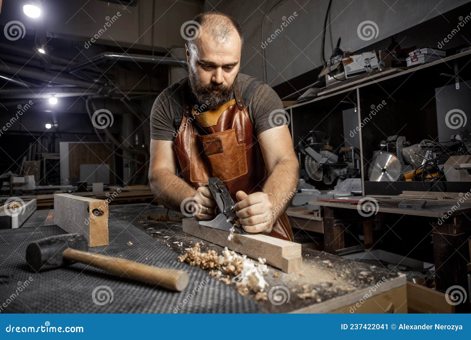 Brutal Master Carpenter in an Apron Planes Tree with a Plane in ...