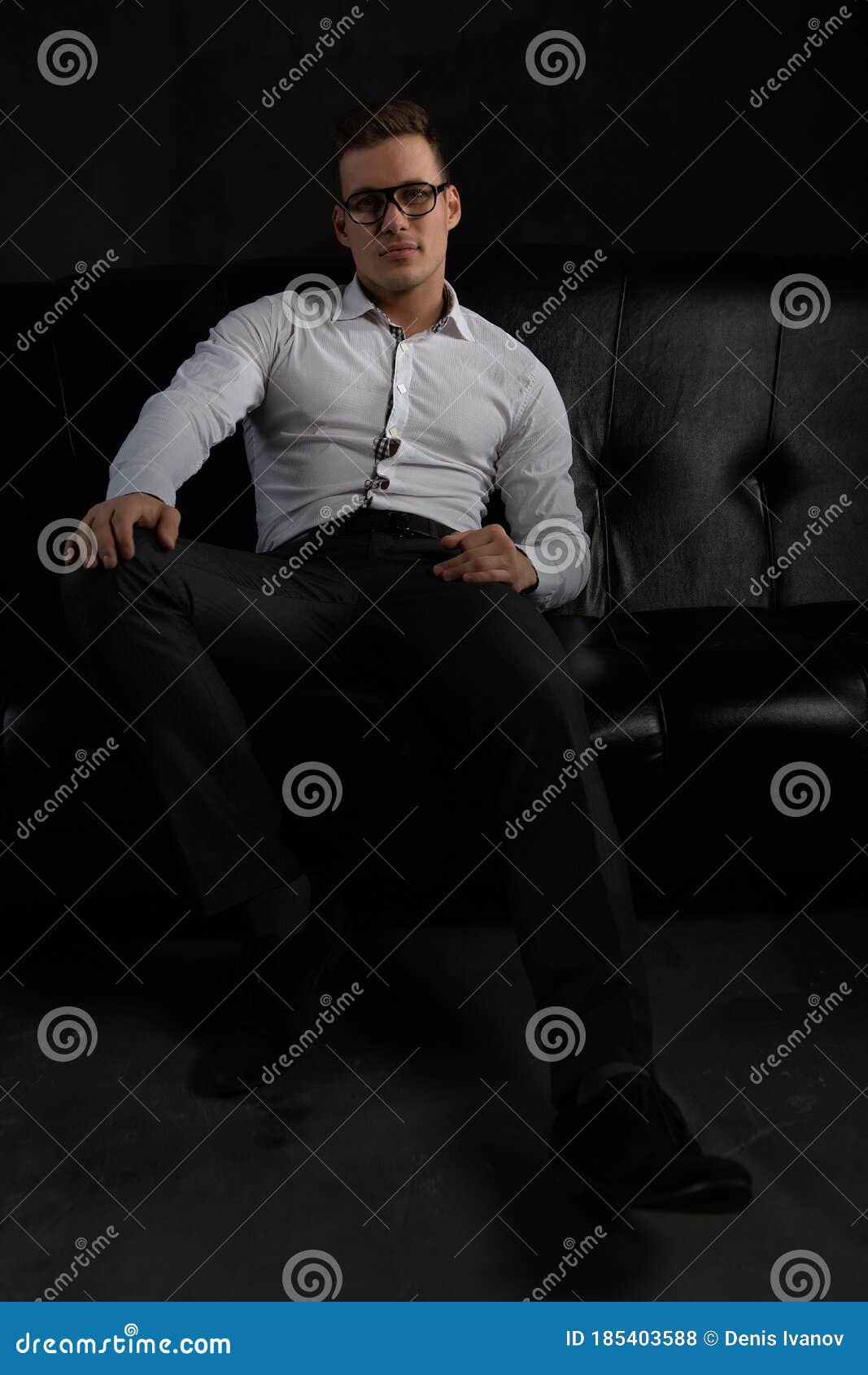 A Brutal Well Dressed Man is Sitting on a Black Sofa Stock Photo ...