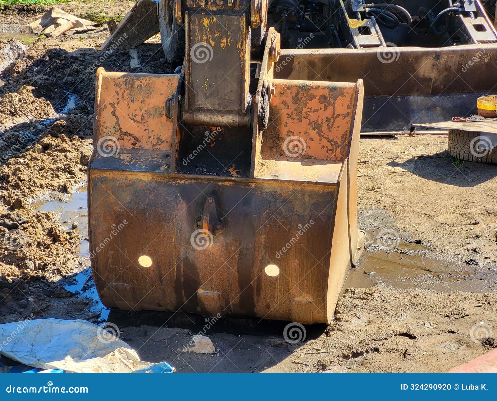 A Bucket of an Idle Excavator is Lying on the Wet Ground. Stock Photo ...