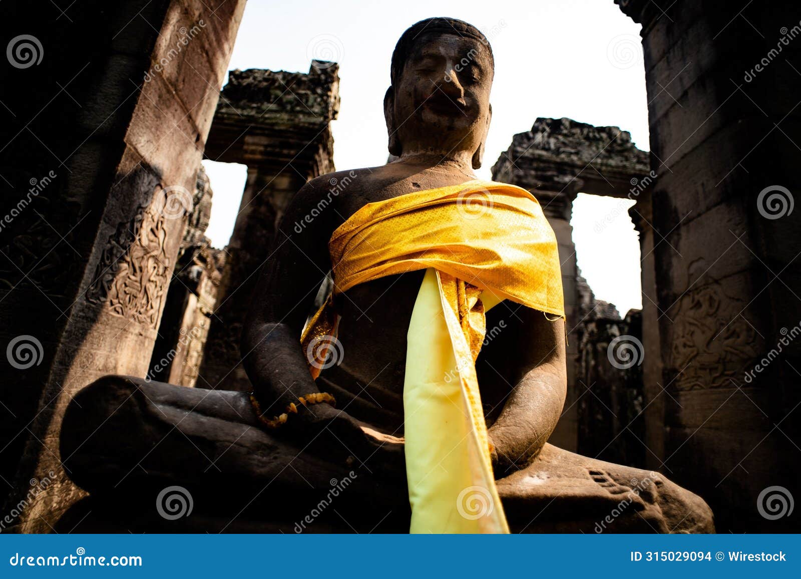 Buddha Statue with Yellow Scarf Sitting in Front of an Arch Stock Photo ...