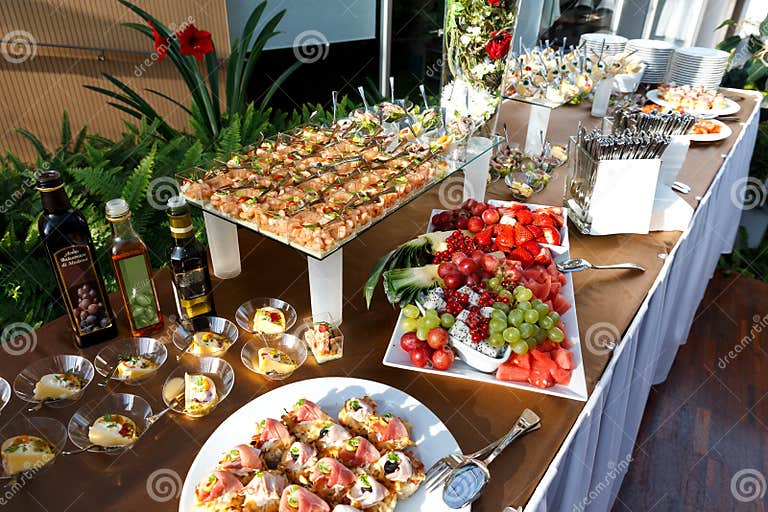 Buffet Table Full of Food in Small Dishes and a Fruit Platter. Stock ...