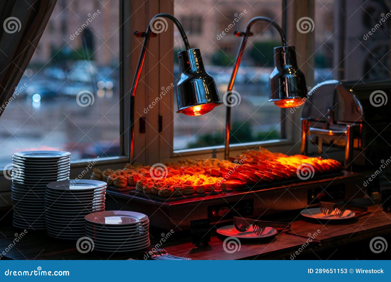 Buffet Table Illuminated with Lamps and Adorned with Plates in Warm ...