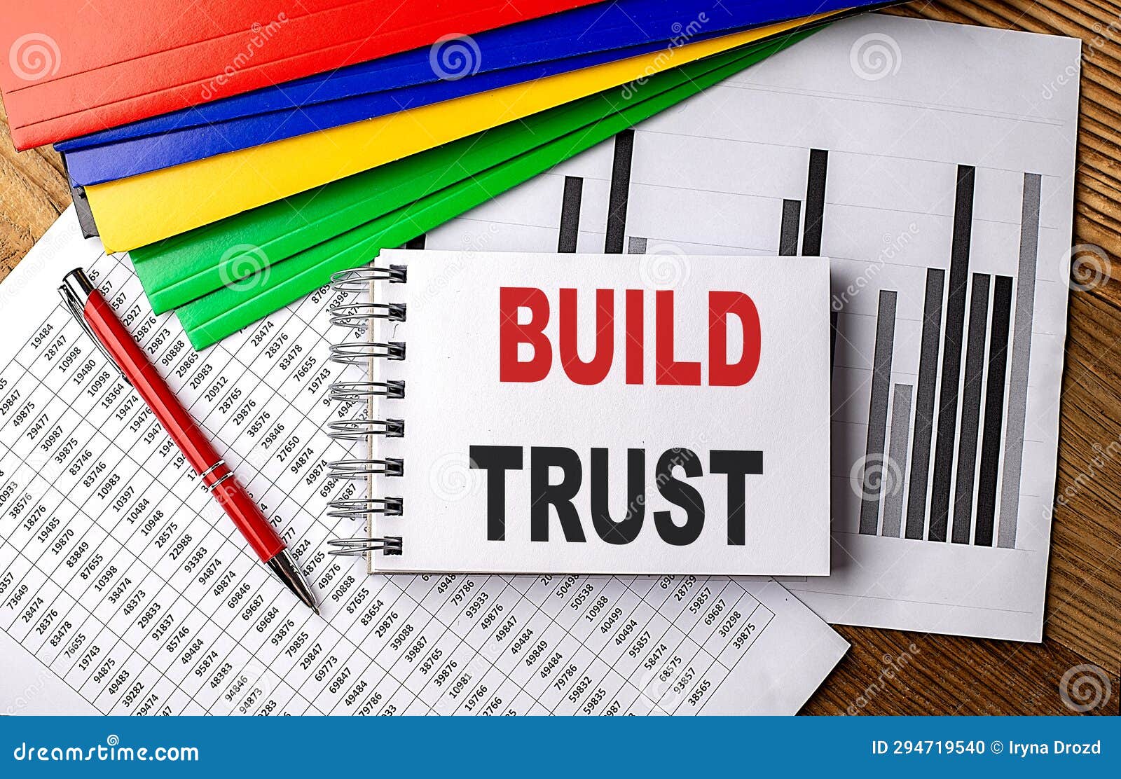 BUILD TRUST Text on Notebook with Pen, Folder on a Chart Background ...