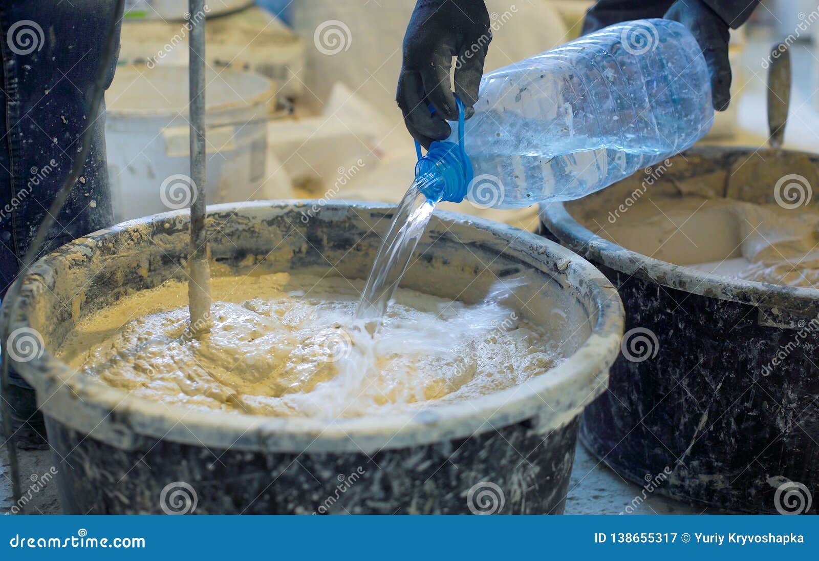 Builder Adding Water To Plaster Solution at Construction Site Stock ...