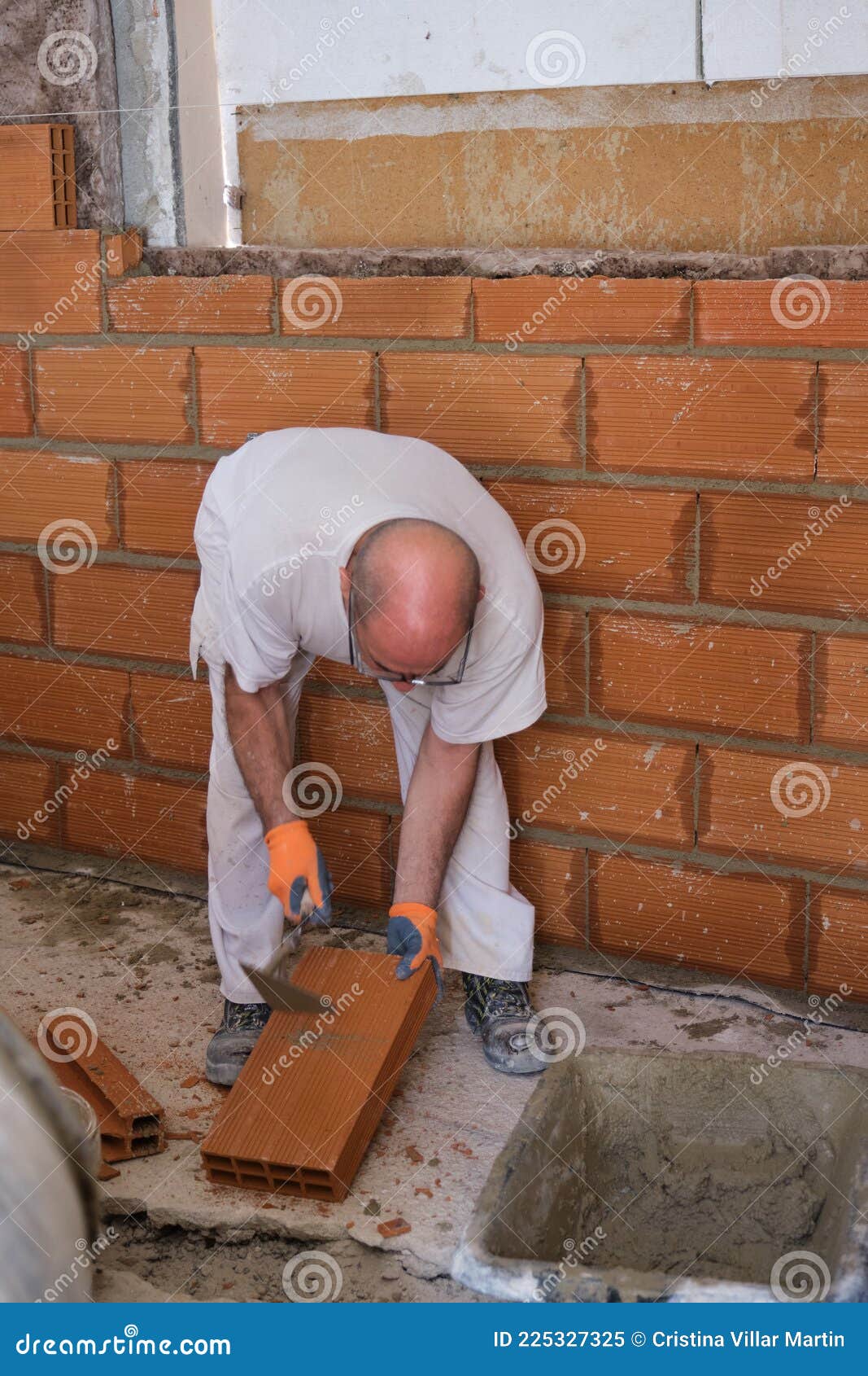 Builder Breaking a Brick To Make it Fix on a Wall. Stock Image - Image ...
