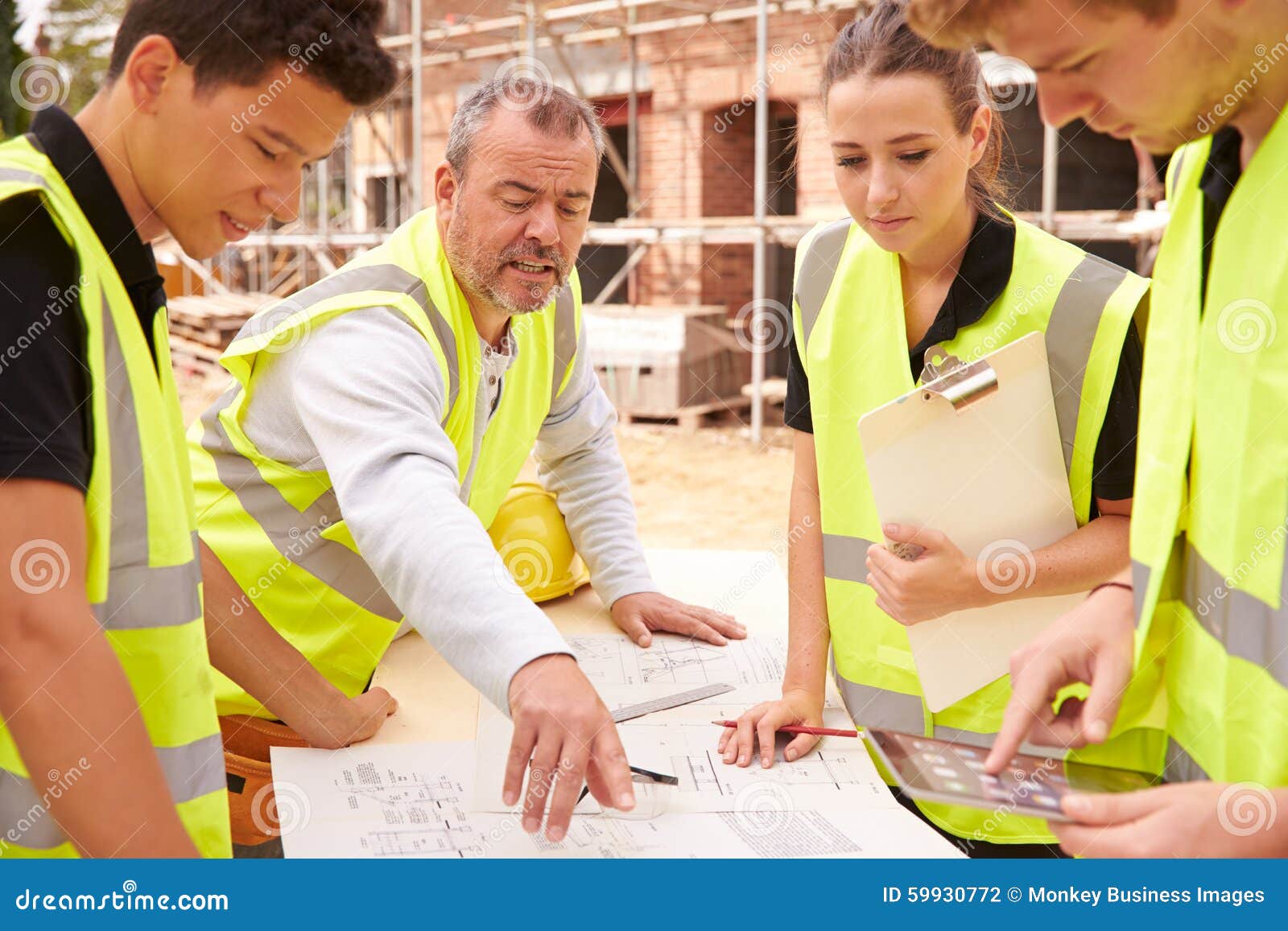 Builder on Building Site Discussing Work with Apprentice Stock Photo ...