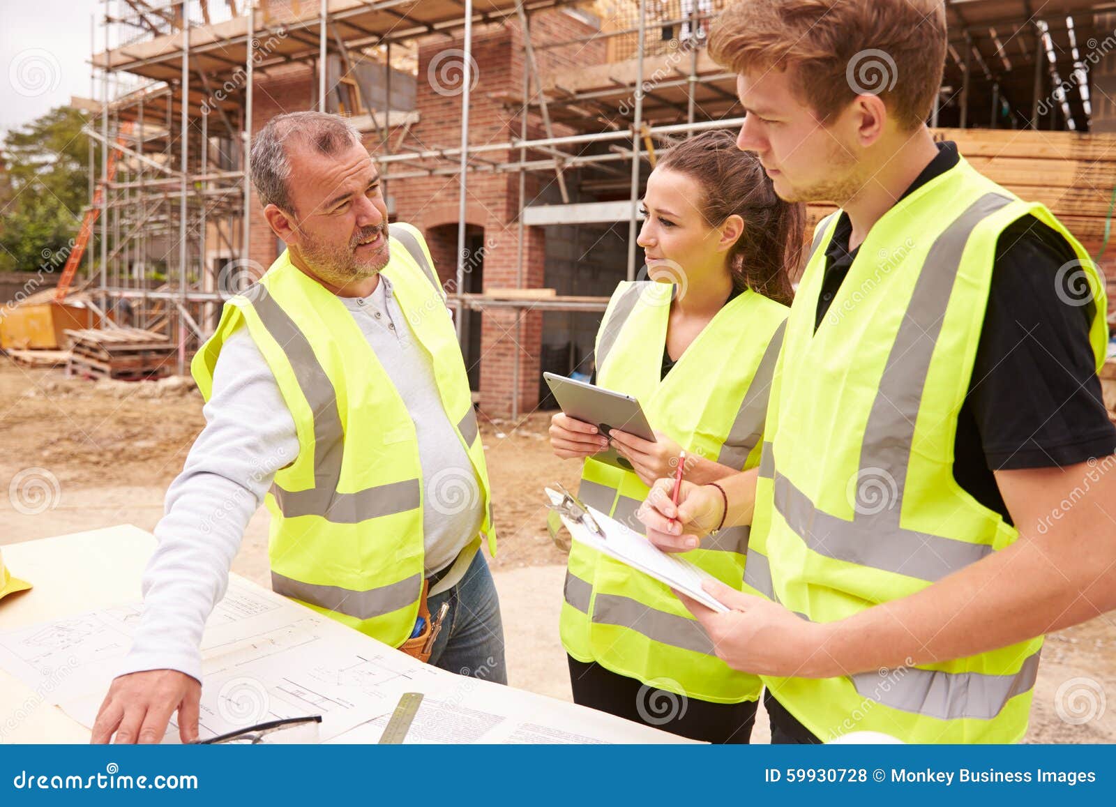 Builder on Building Site Discussing Work with Apprentices Stock Photo ...
