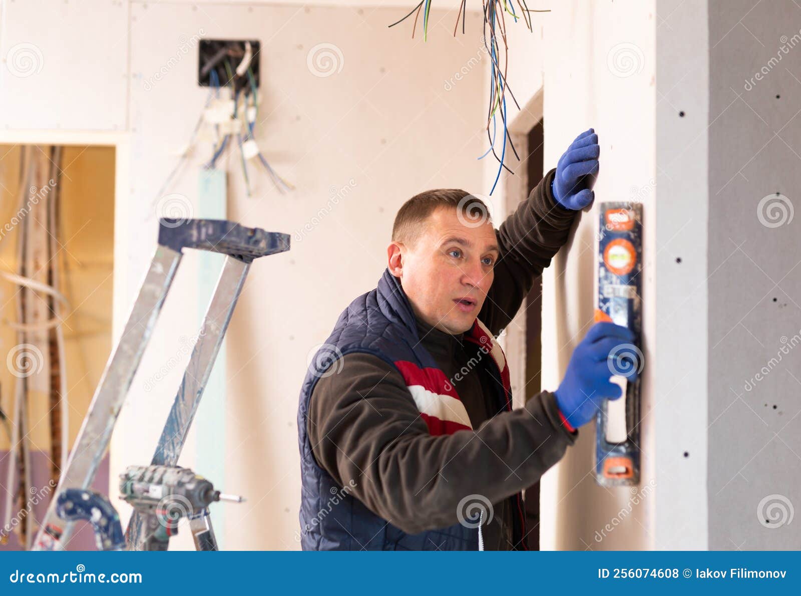 Builder Checks the Vertical of the Wall Using Level Stock Photo - Image ...