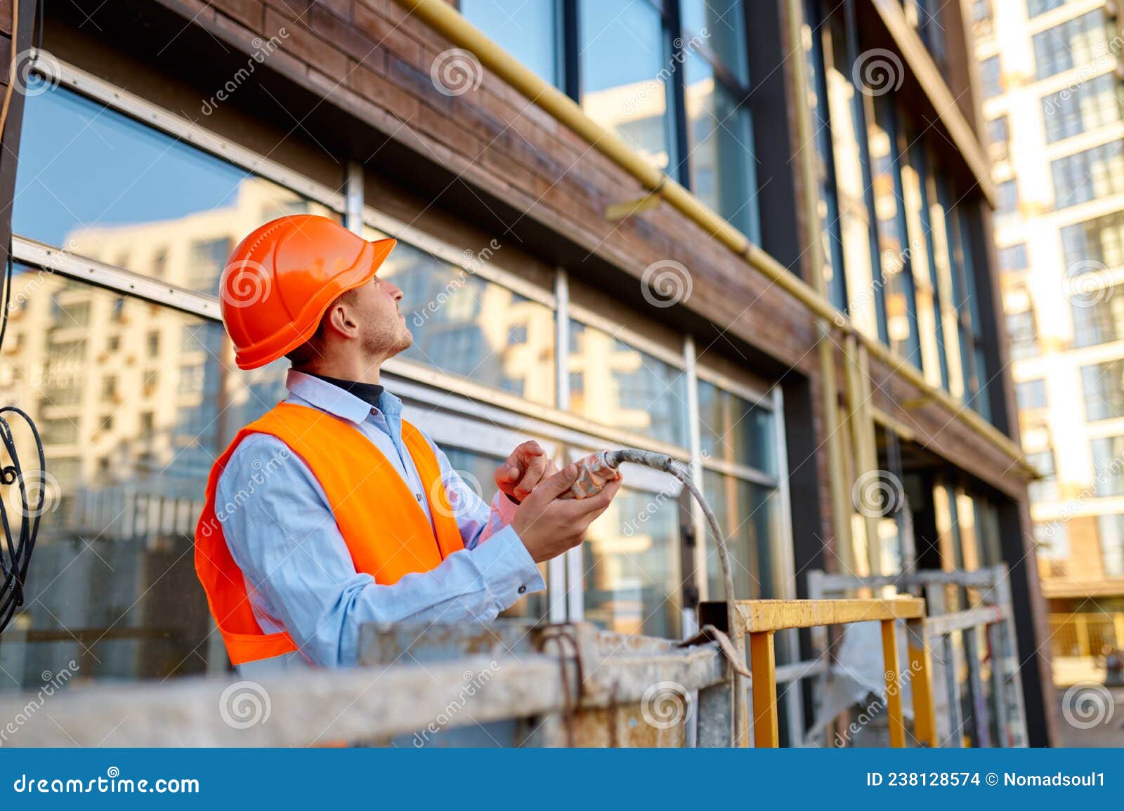 Builder Climbing in Cradle Over Building Facade Stock Photo - Image of ...