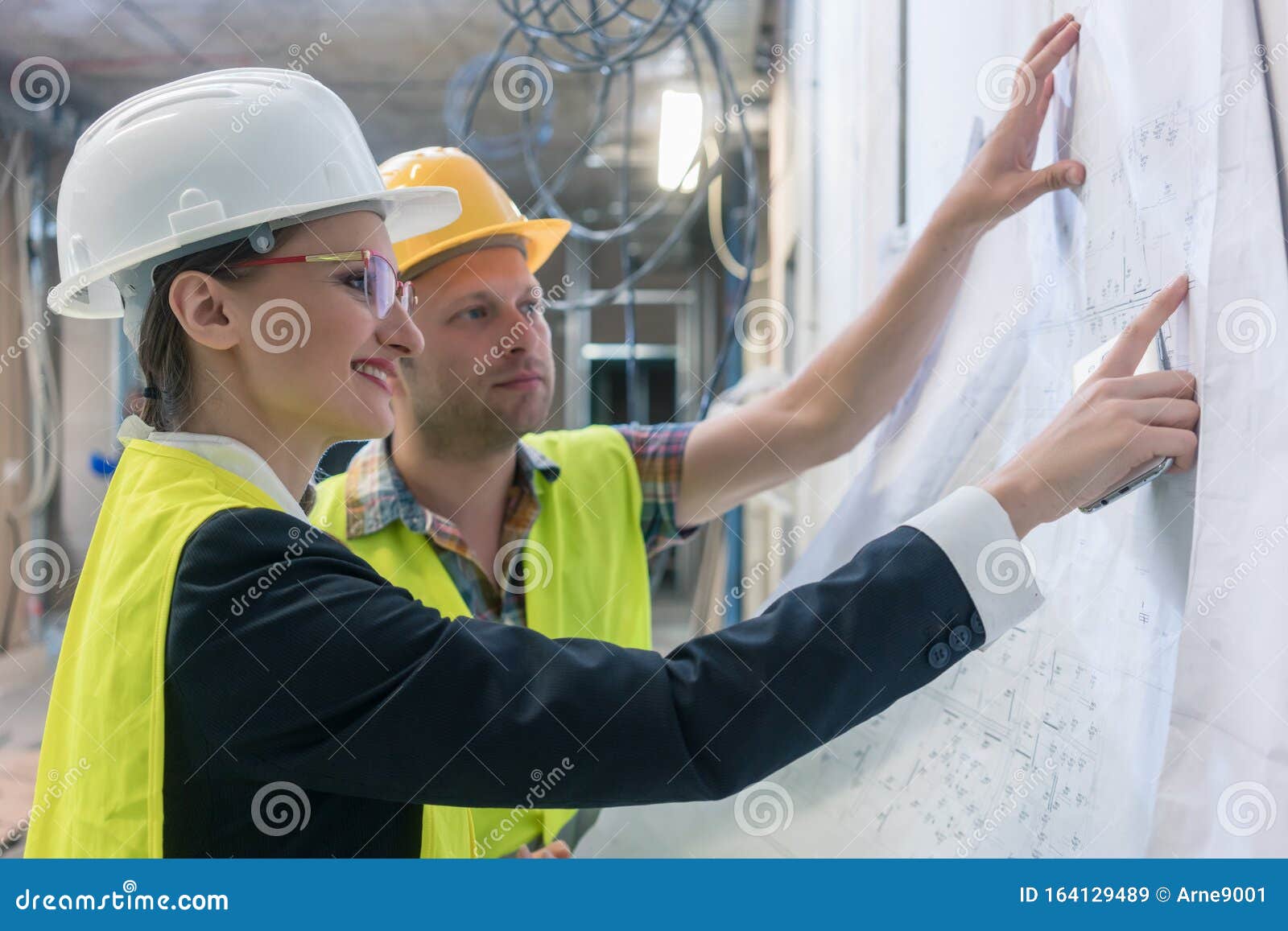 Builder and Construction Worker Looking at Building Blueprint Stock ...