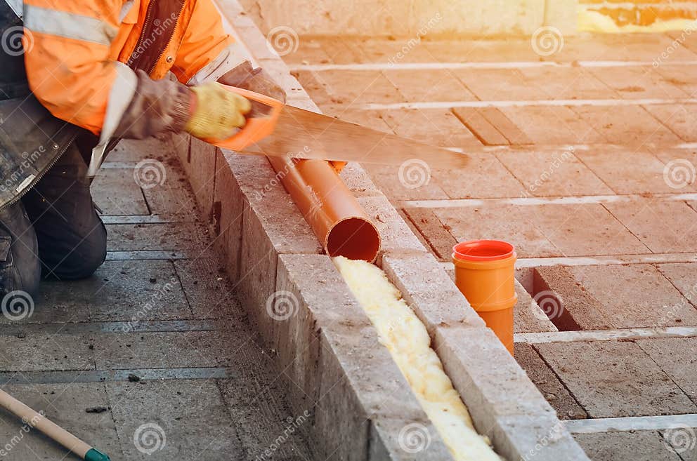 Builder Cutting Plastic Pipe with Hand Saw during New House Internal ...