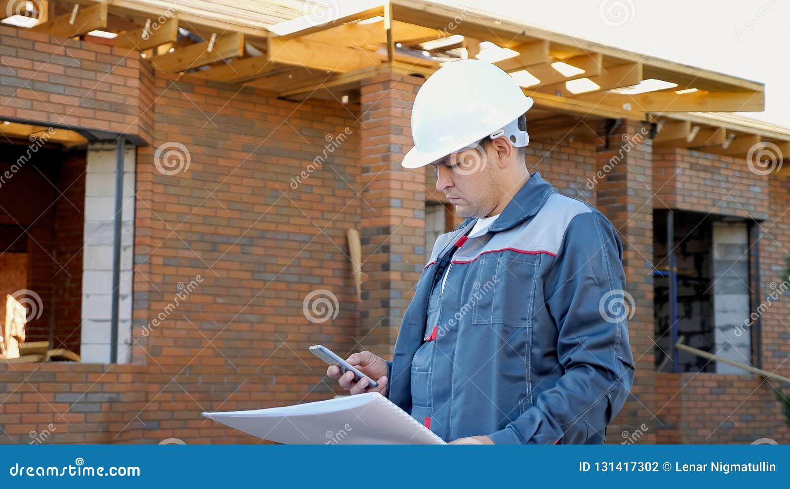 Builder with Drafts Using Phone on Site Stock Photo - Image of employee ...