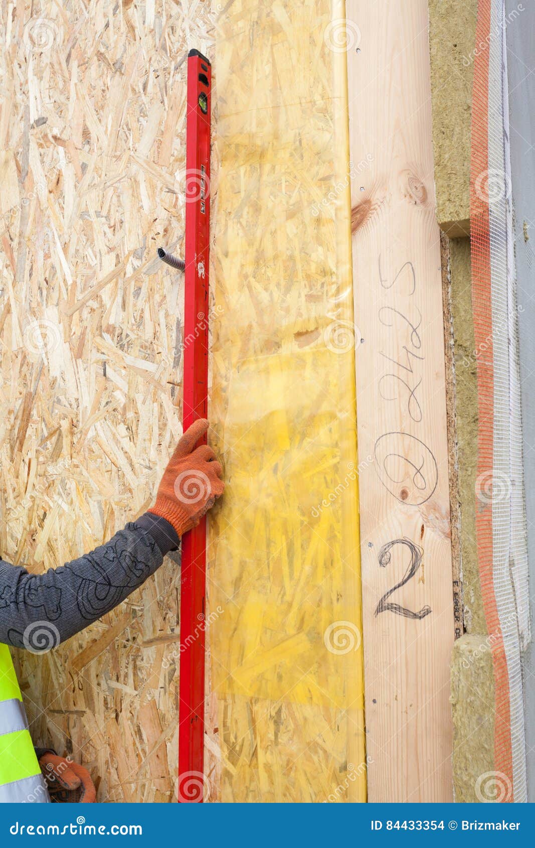 Builder Ensuring that a Wall is Vertical Holding a Builders Level ...