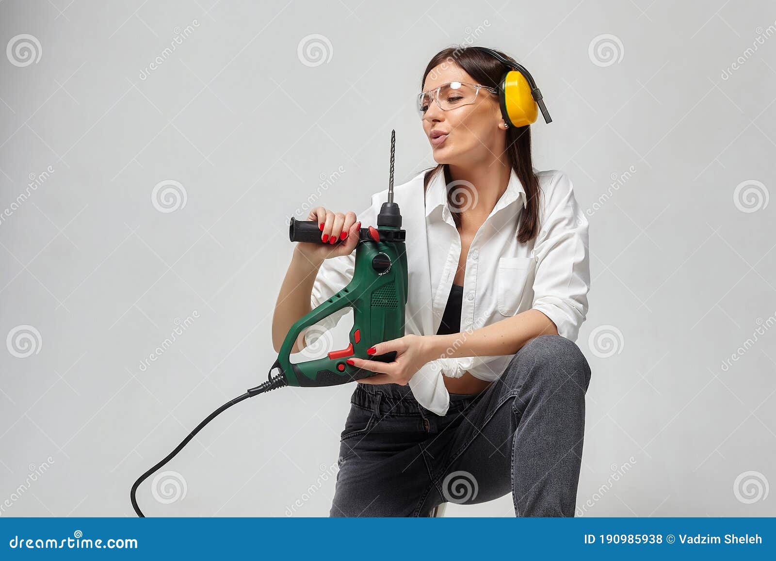 Builder Girl Holding a Drill. Concept of Housewives, Working Tools and ...