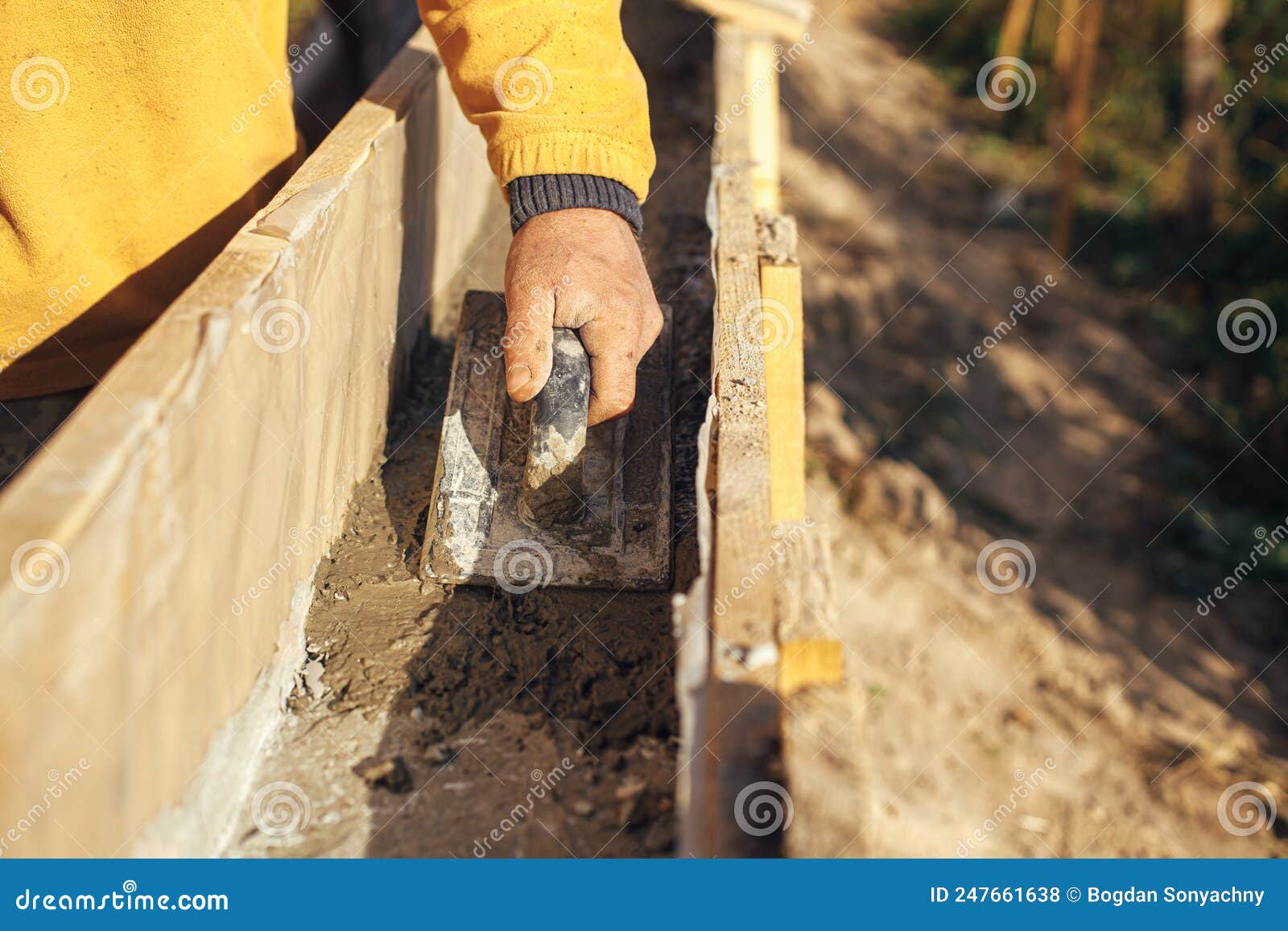 Builder Hand with Trowel Working with Concrete in Wooden Formwork with ...