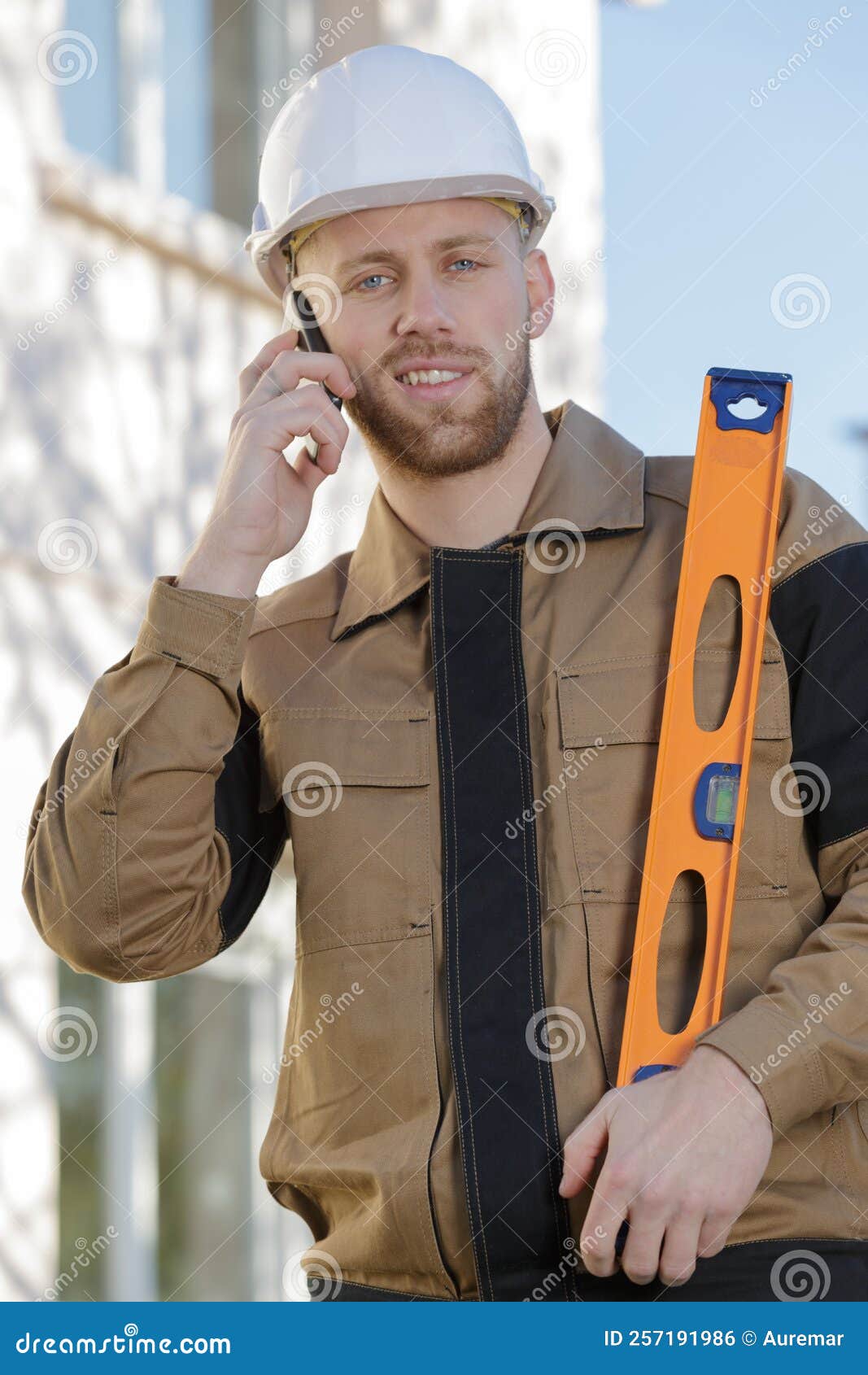 Builder Holding Spirit Level and Talking on Telephone Stock Photo ...