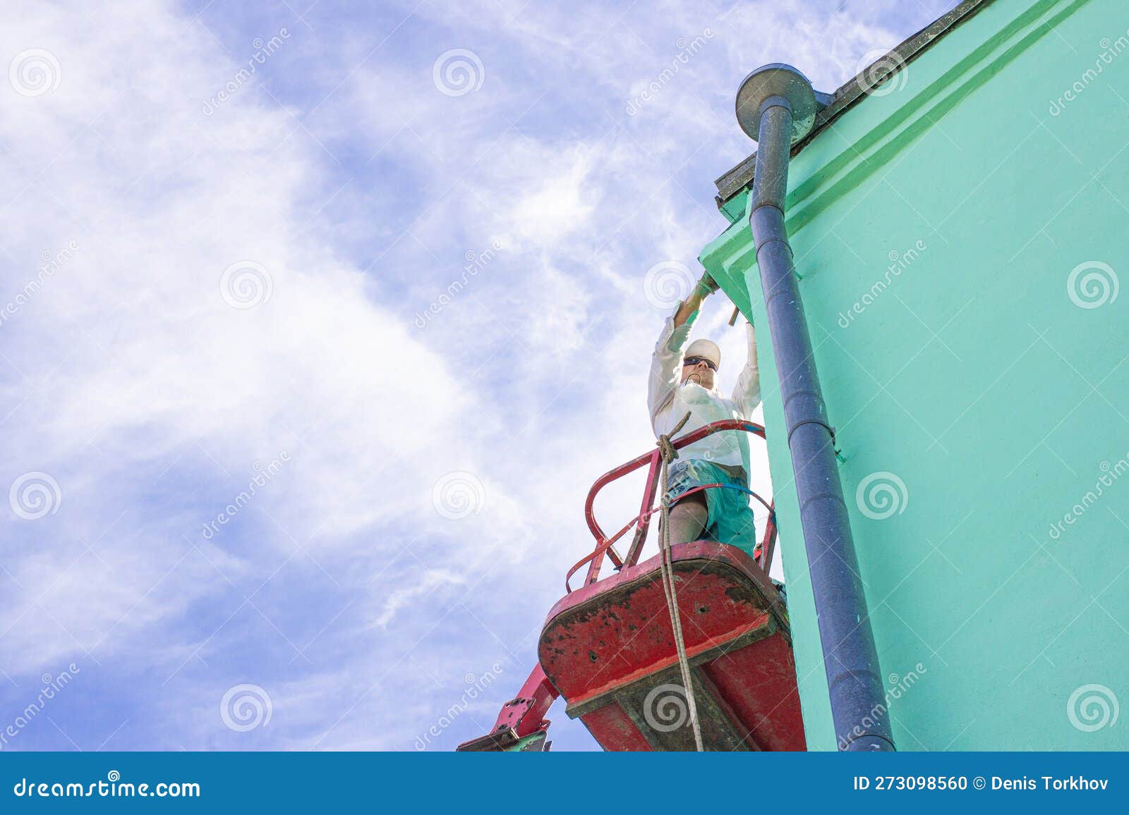 A Builder on a Hydraulic Lift is Repairing a Building, Using a ...