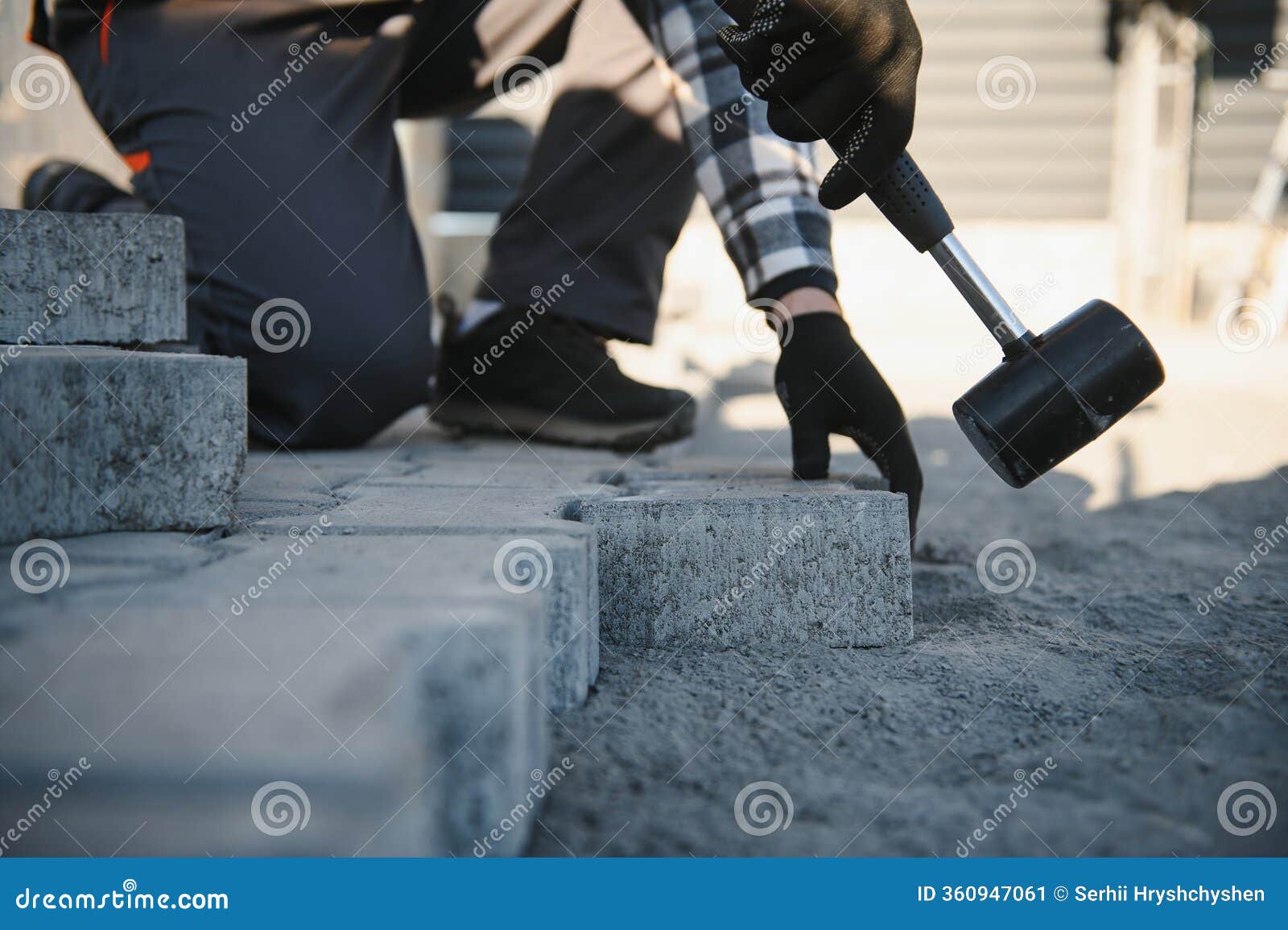 Builder Laying a Paving Brick Placing it on the Sand Foundation with ...