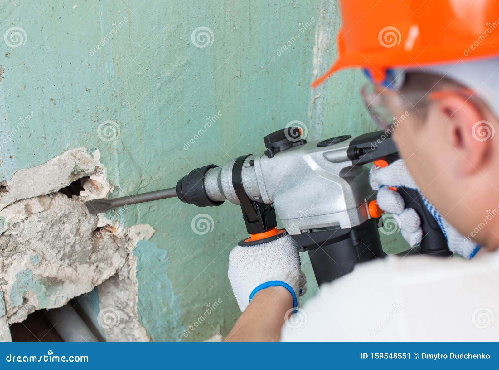 The Builder is Making Hole in Wall at Construction Site with Hammer ...