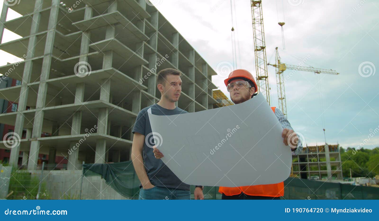 Builder with a Male Client Near Building Under Construction Outdoors ...