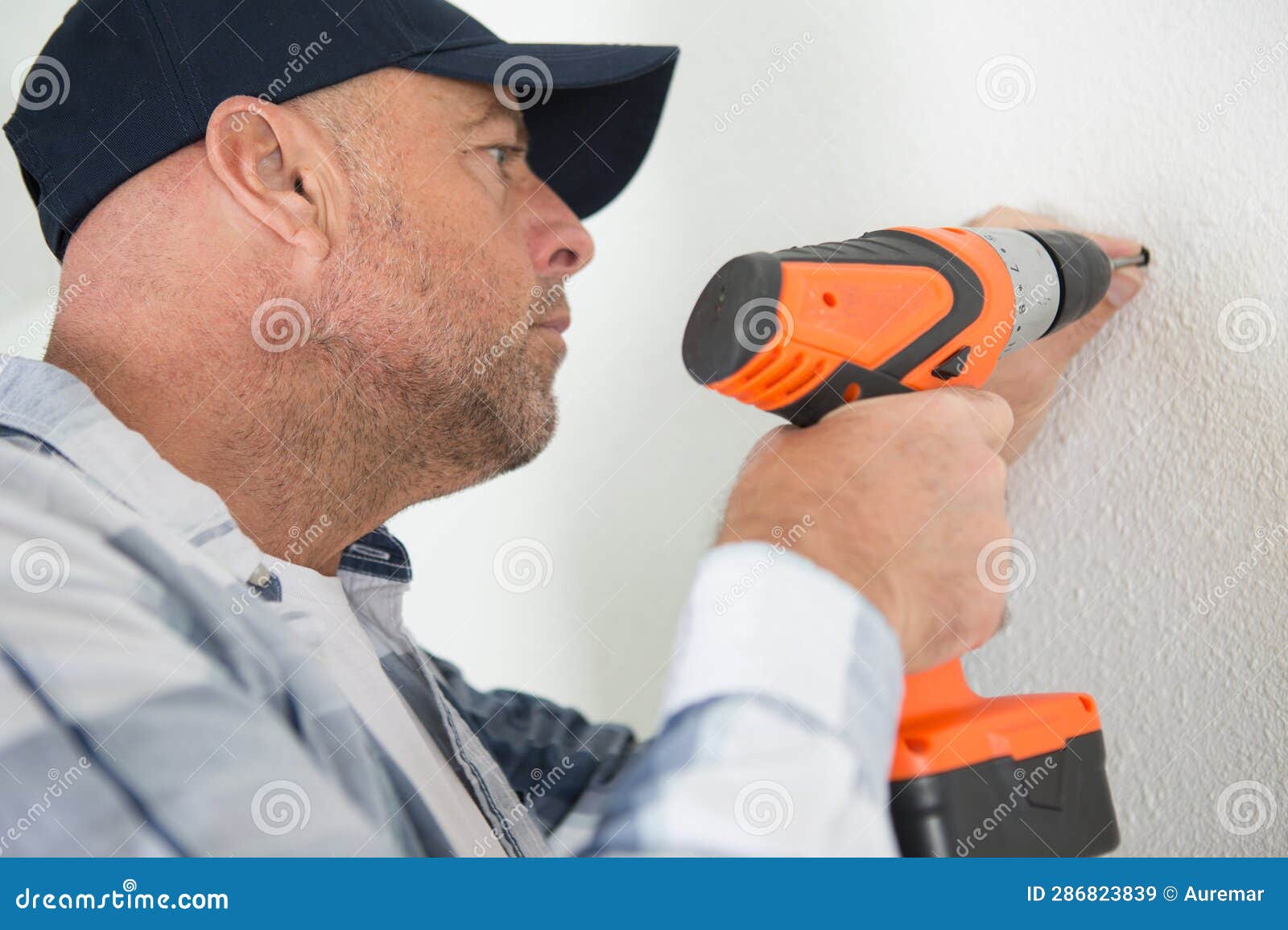 Builder man drilling wall stock image. Image of driller - 286823839