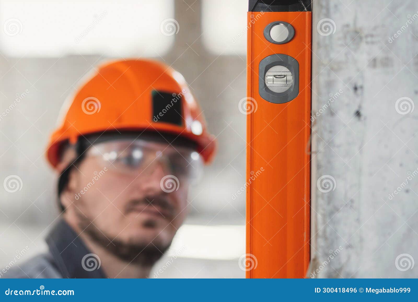 A Builder Man in a Hard Hat Checks the Vertical Level of a Reinforced ...