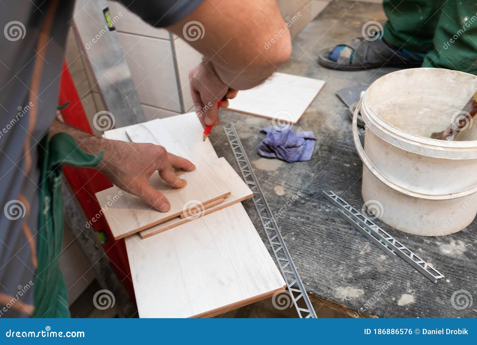 A Construction Worker Measures and Prepares To Cut Ceramic Tiles Stock ...