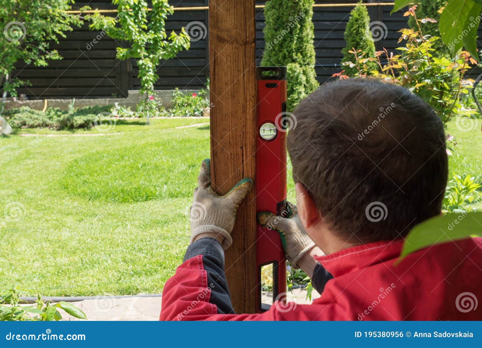 Builder Measures the Level of Installation of a Wooden Pillar with a ...