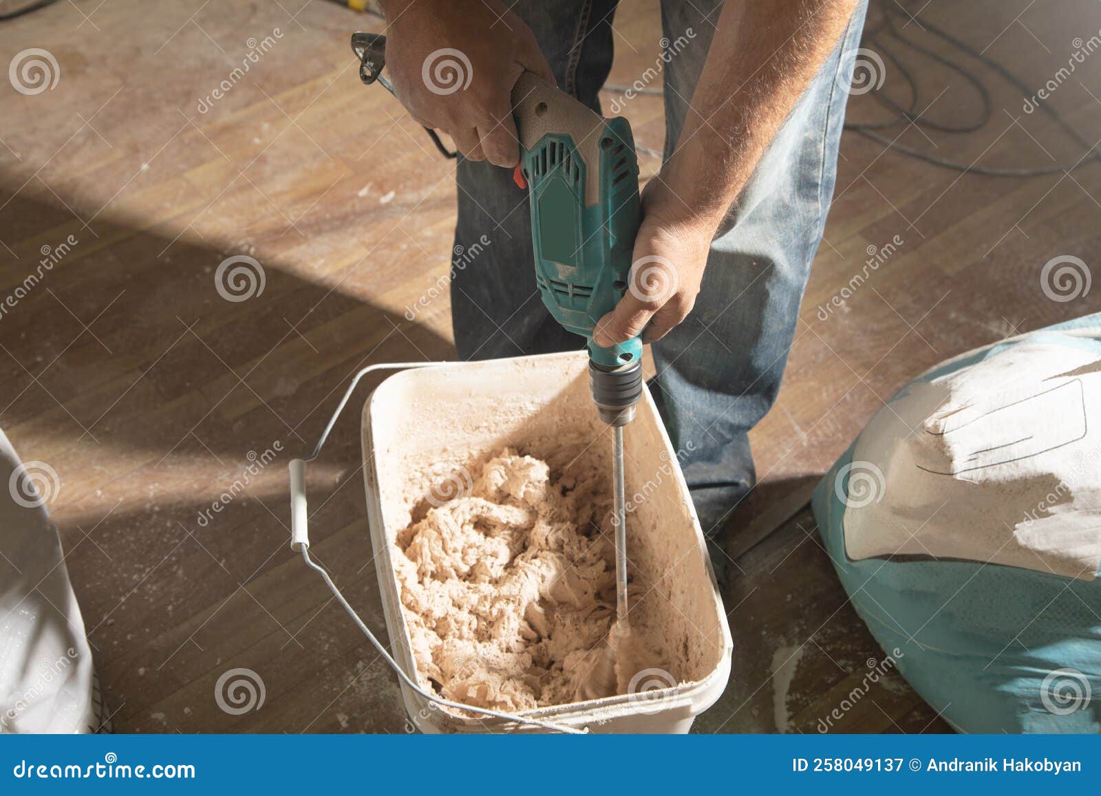The Builder Mixes The Construction Mixture In A Container For Guiding ...