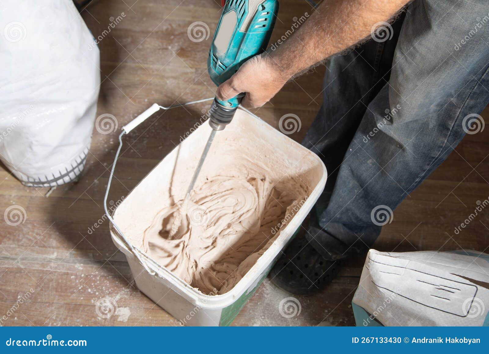 The Builder Mixes The Construction Mixture In A Container For Guiding ...