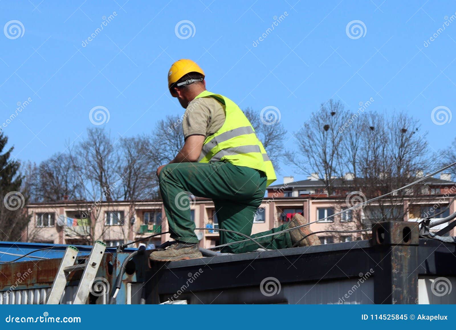 Builder in Overalls at the Construction Site. Repairs at Altitude ...