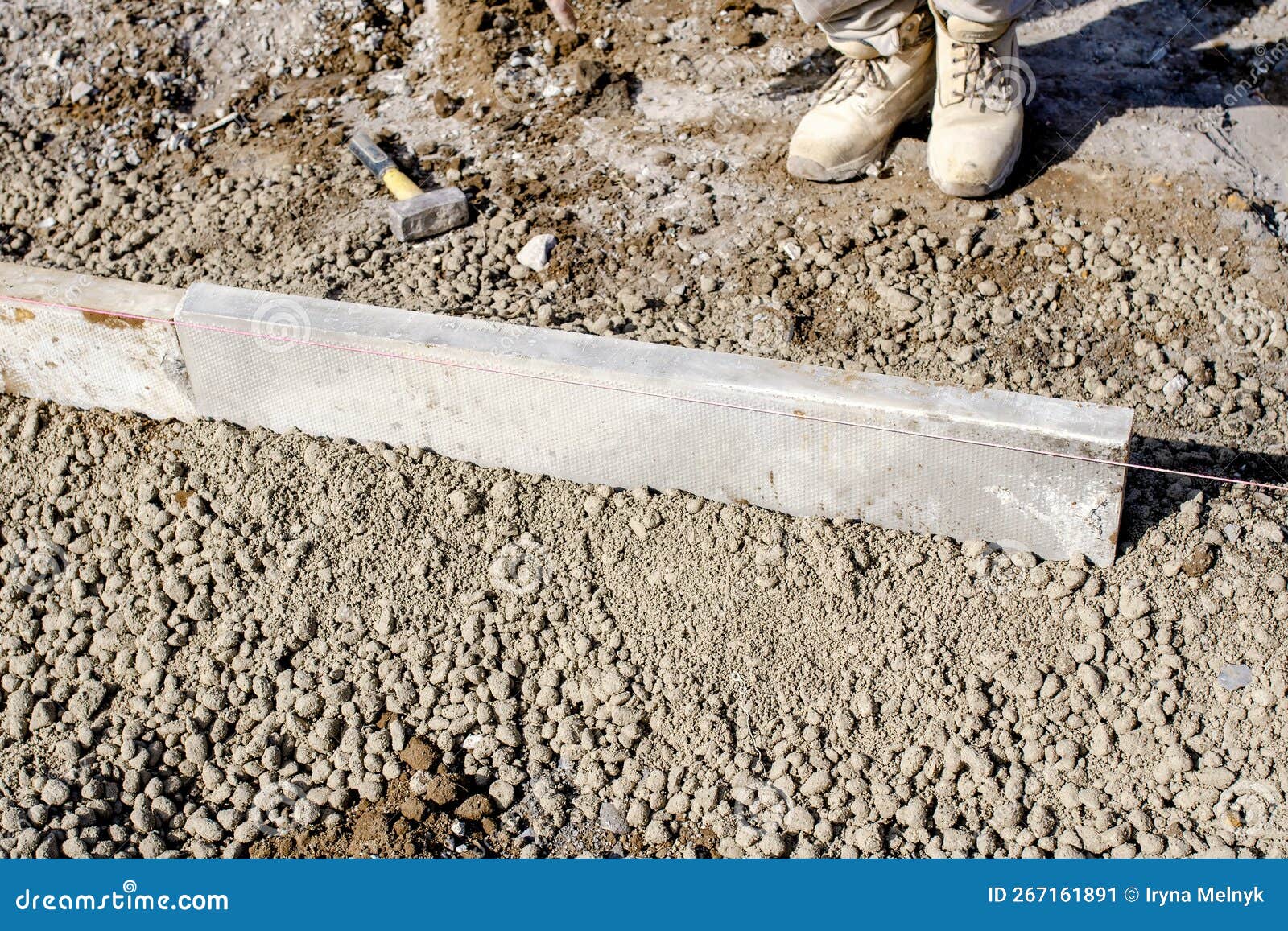 Builder Placing Edging Pin Kerb on Semi-dry Concrete Using a String ...