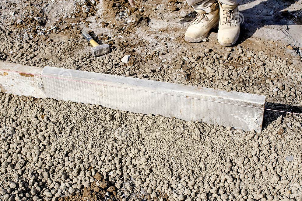 Builder Placing Edging Pin Kerb on Semi-dry Concrete Using a String ...