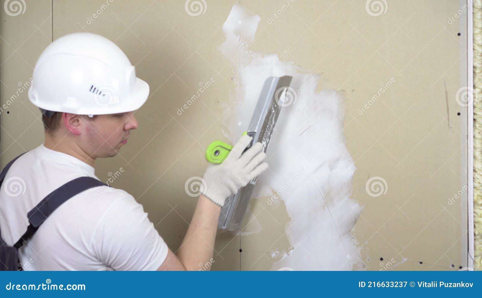 The Builder Plasters the Wall in the Room. a Man in Special Clothes and ...