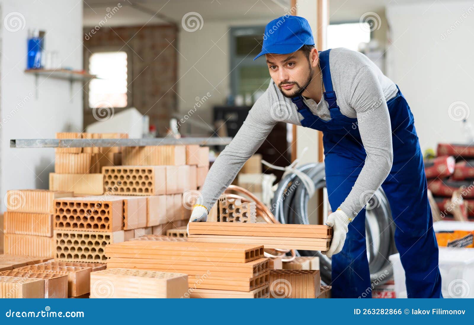 Builder Preparing Bricks for Work in Building Under Reconstruction ...
