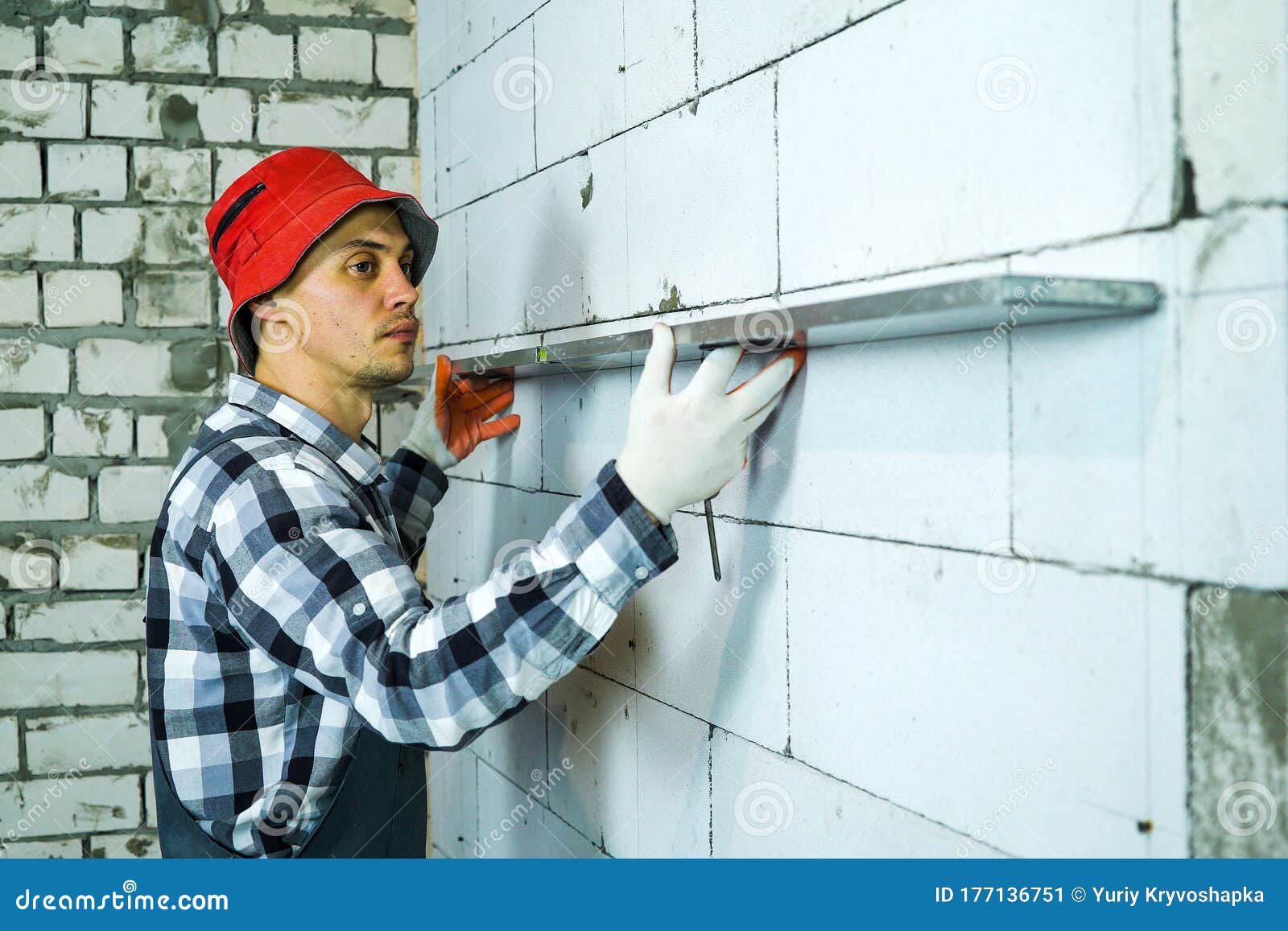 Builder Pressing Construction Ruler To Interior Wall Checking Its ...