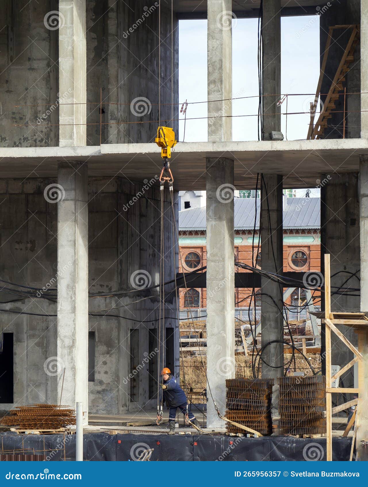 The Builder Pulls a Metal Cable with Hooks Towards Him To Pick Up and ...