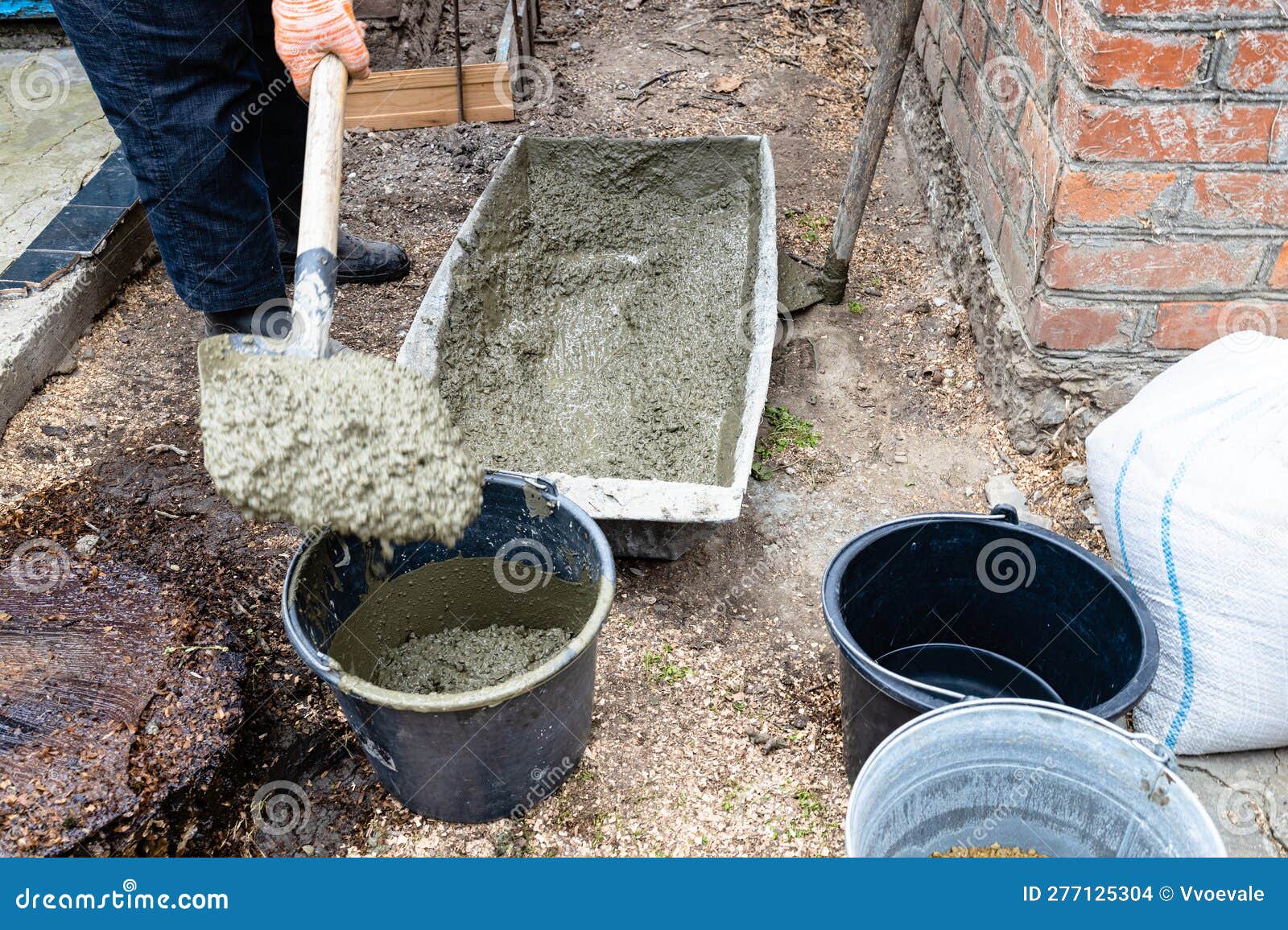 The Builder Puts The Mortar Under The Brickwork With A Trowel. Building ...