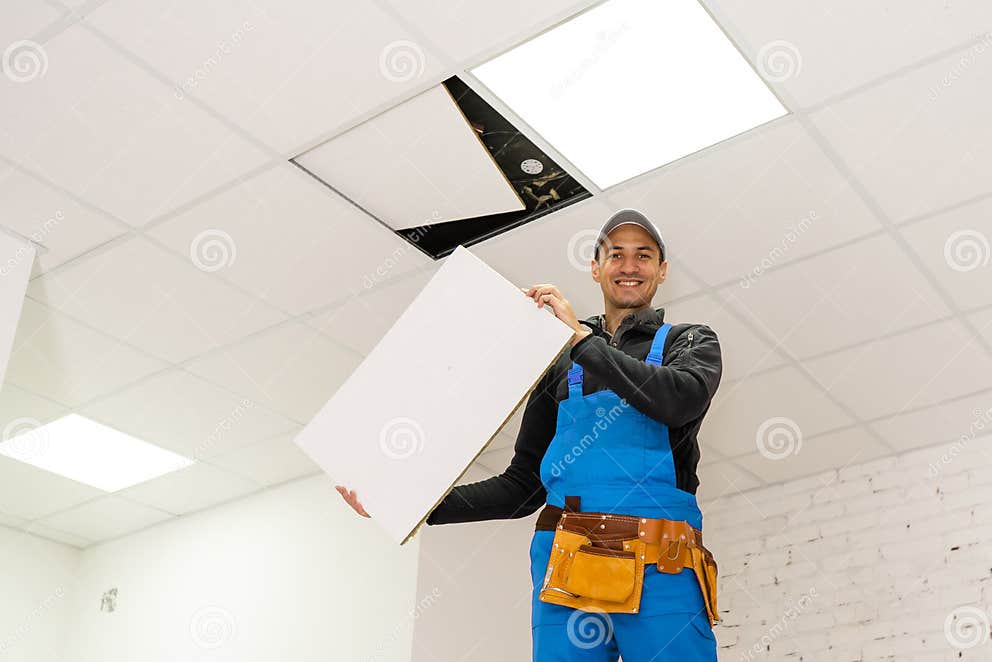 A Builder Replacing Ceiling Panel, Working, Armstrong. Stock Photo ...