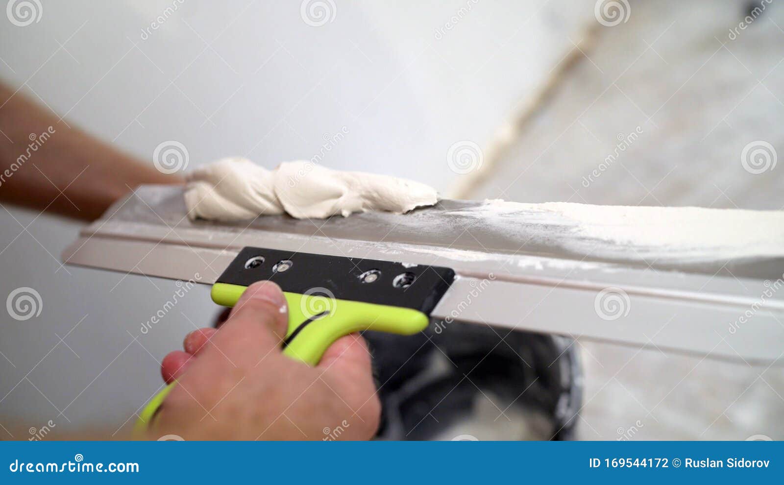 Builder Smears a Putty Knife with a Spatula. Worker Puts Mortar on a ...
