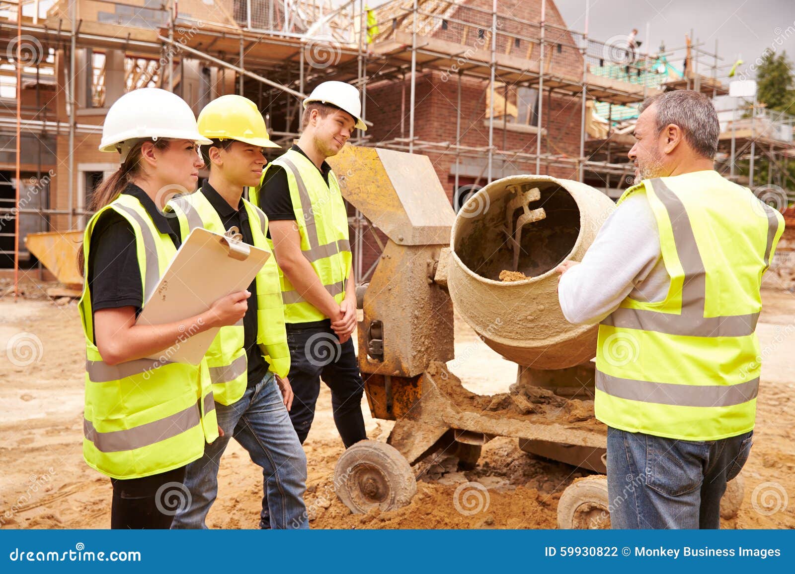 Builder Using Cement Mixer on Building Site with Apprentices Stock ...