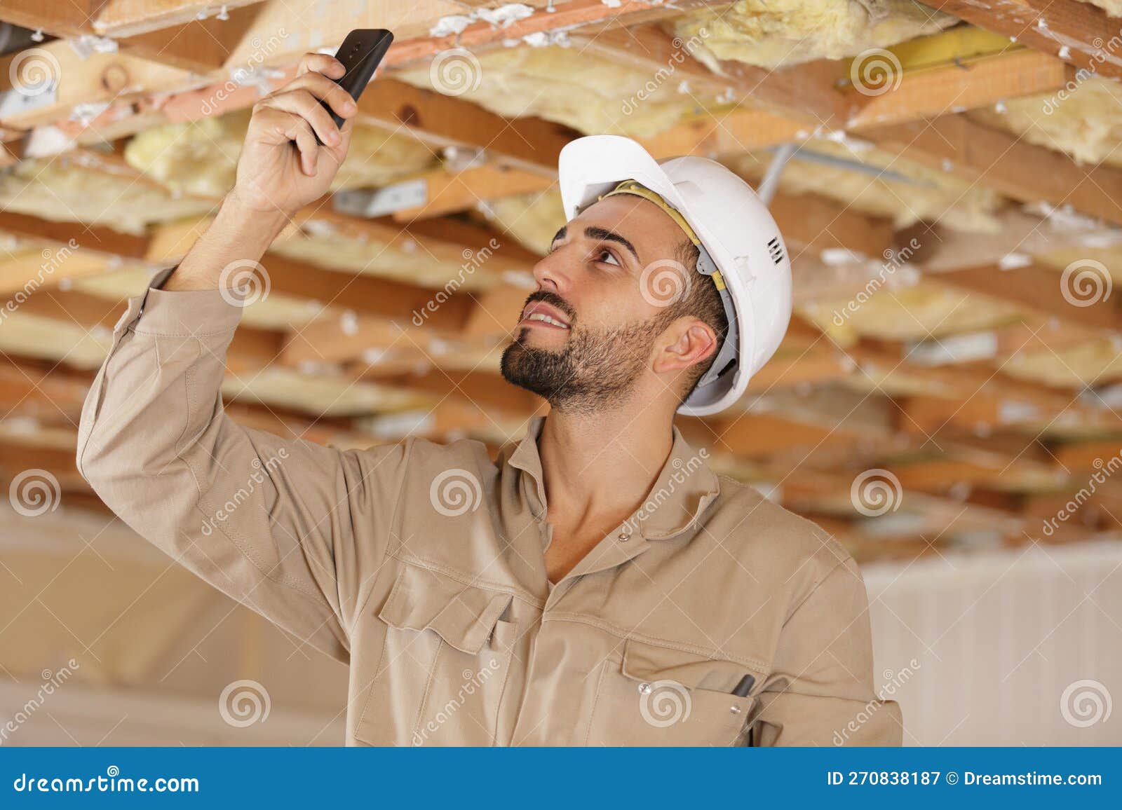 Builder Using Smartphone To Photograph Ceiling Joists Stock Image ...