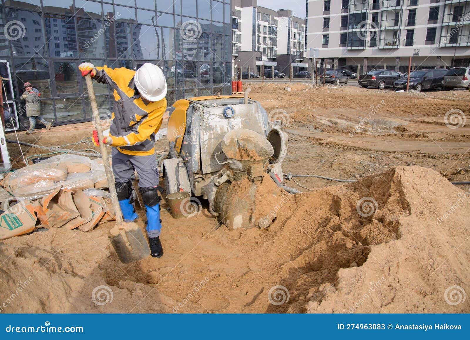 A Builder in Work Clothes is Doing His Job, Leveling the Floor, Pouring ...
