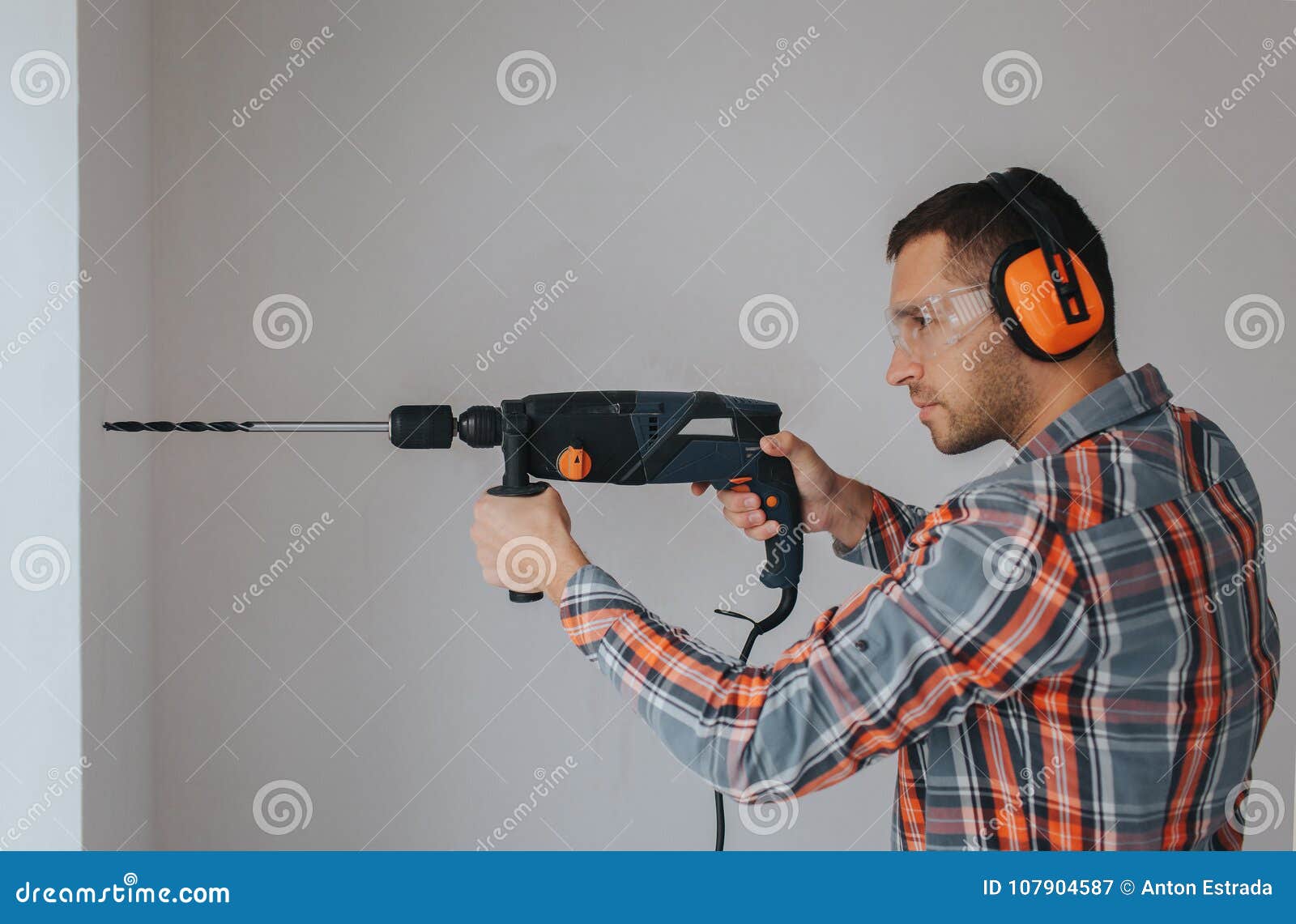 Builder Worker with Equipment Making Hole in Wall at Construction Site ...