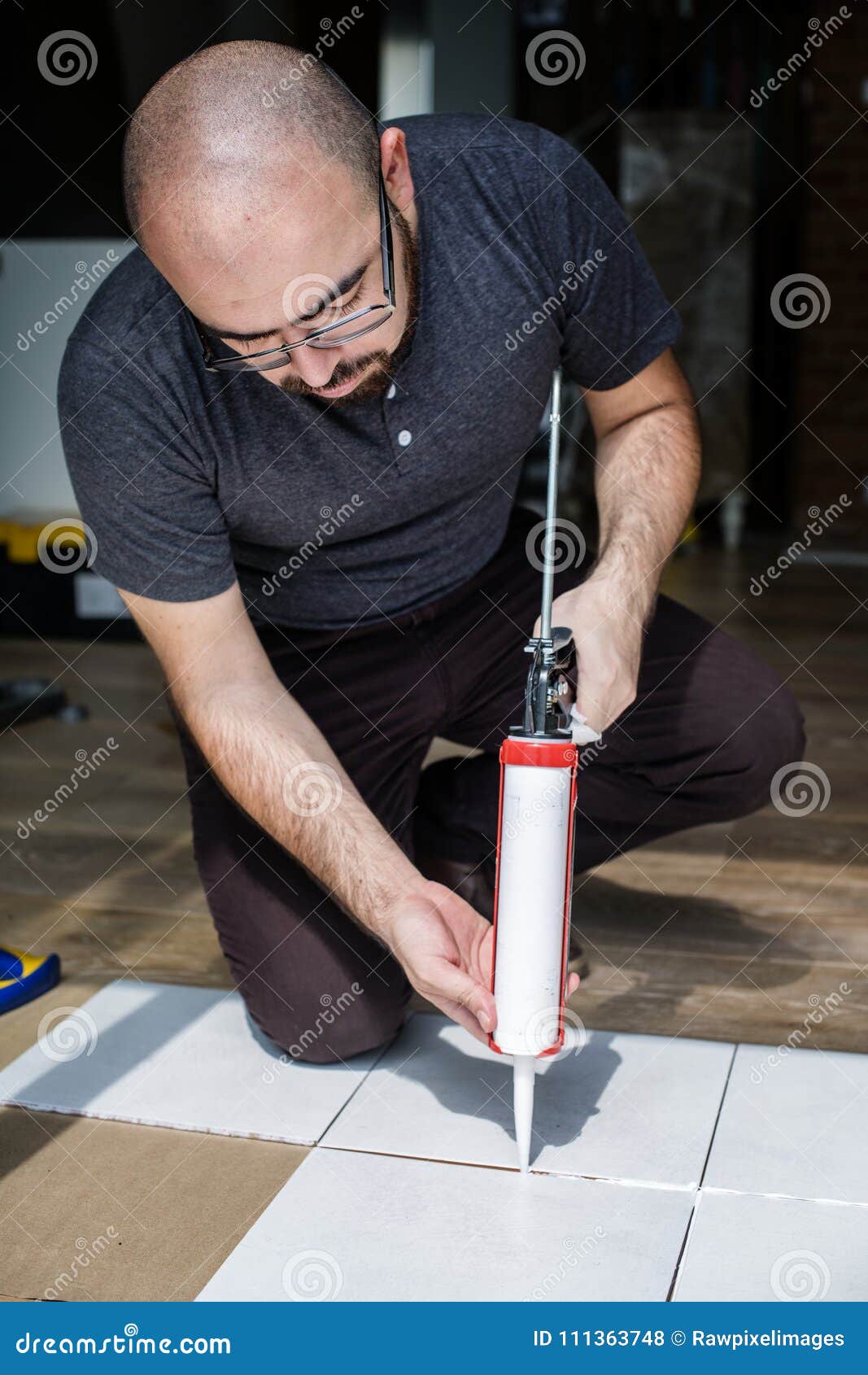 A builder working on tiles stock photo. Image of handyman - 111363748
