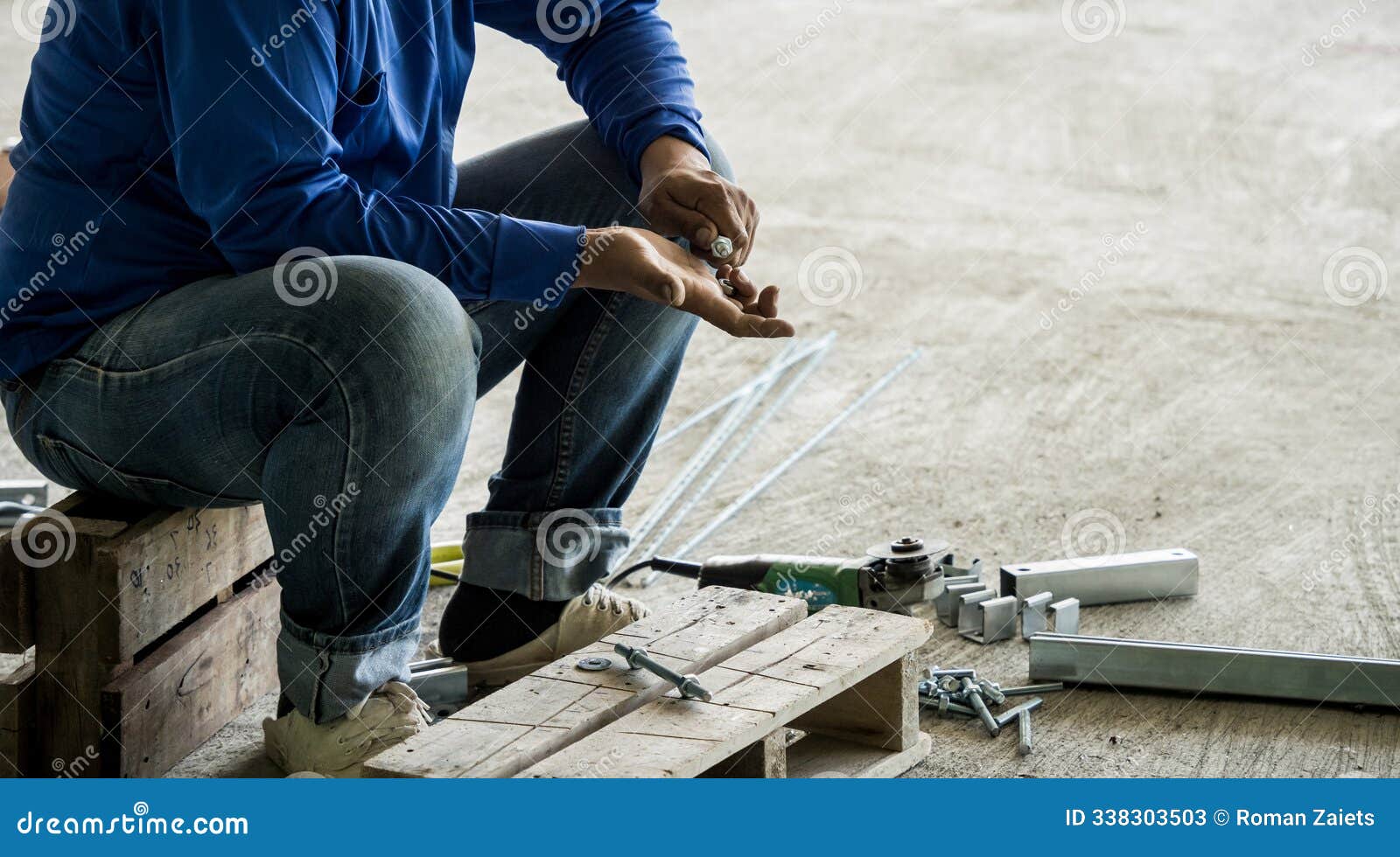 A Builder Works with Screws and Nuts on a Wooden Pallet Stock Image ...