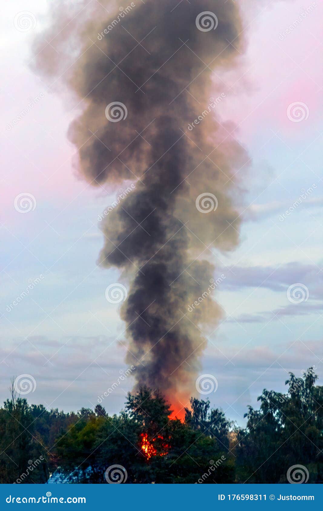 The Building Burns with Fire and Black Smoke Against the Evening Sky ...